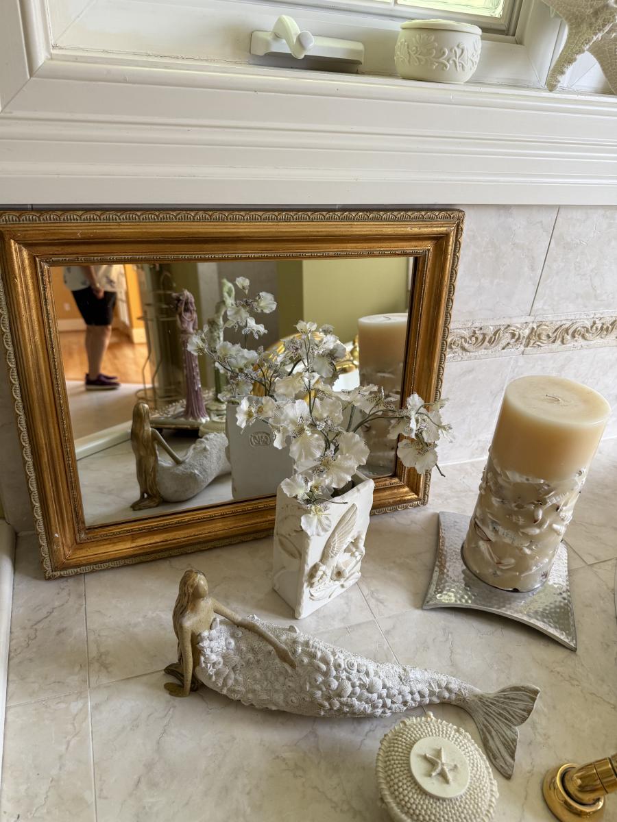 Small gold mirror and ocean themed decor | EstateSales.org