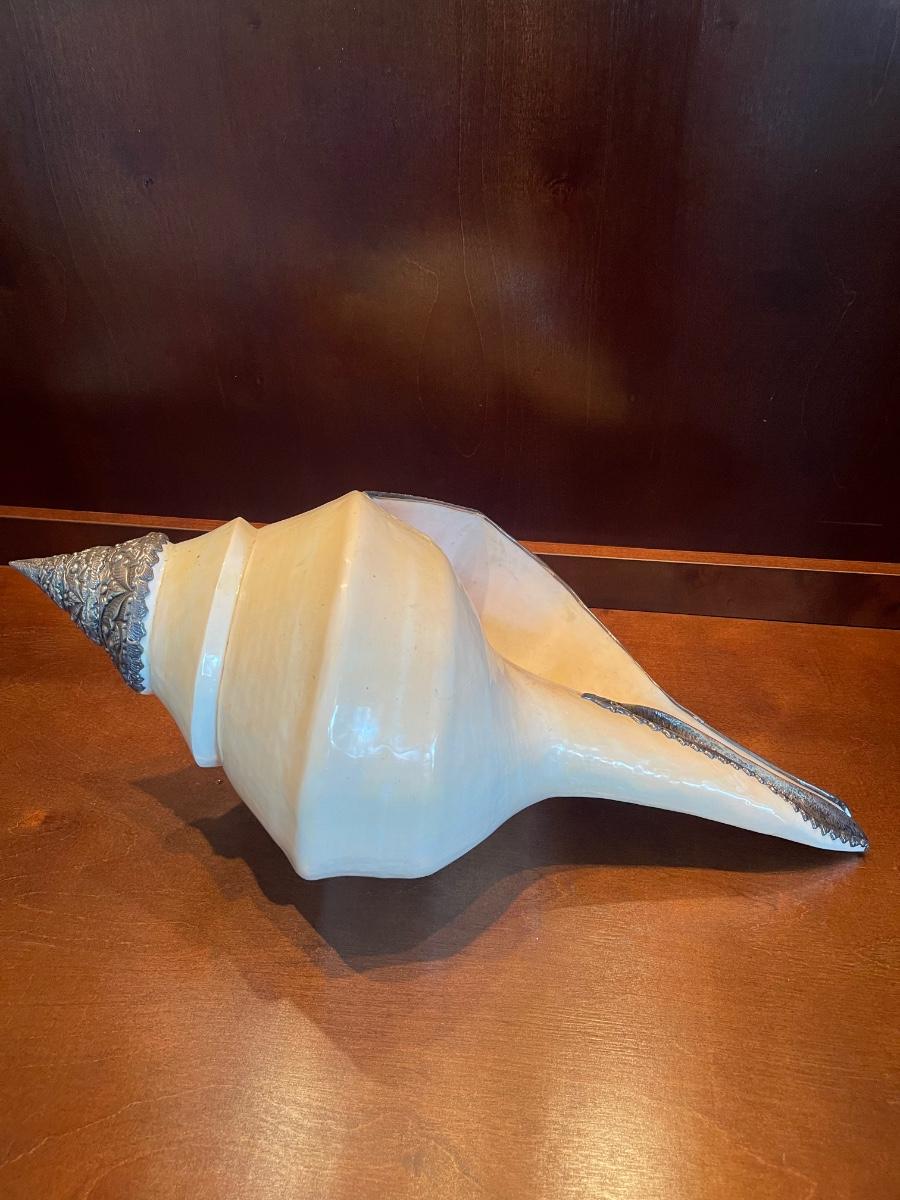 This is a heavy real shell trimmed in silver from Bali. Approx 22” long ...
